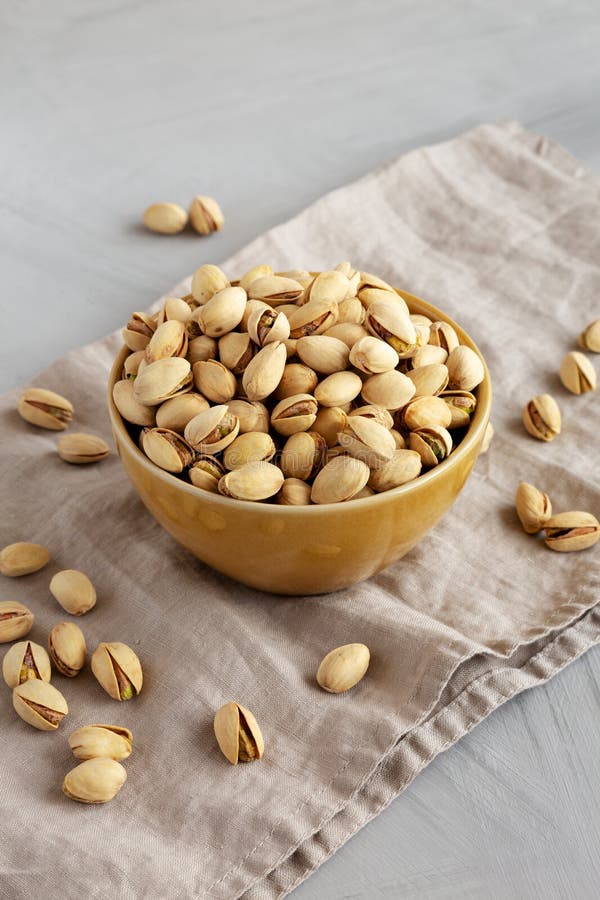 Roasted and Salted Pistachios in a Bowl on a Gray Background, Side View ...