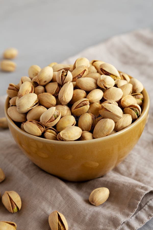 Roasted and Salted Pistachios in a Bowl on a Gray Background, Side View ...