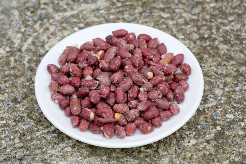 Roasted Salty Peanuts in a White Plate on Concrete Background. Stock ...