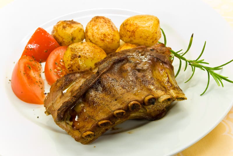 A Roasted Suckling Pig with Potatoes and Salad Stock Image - Image of ...