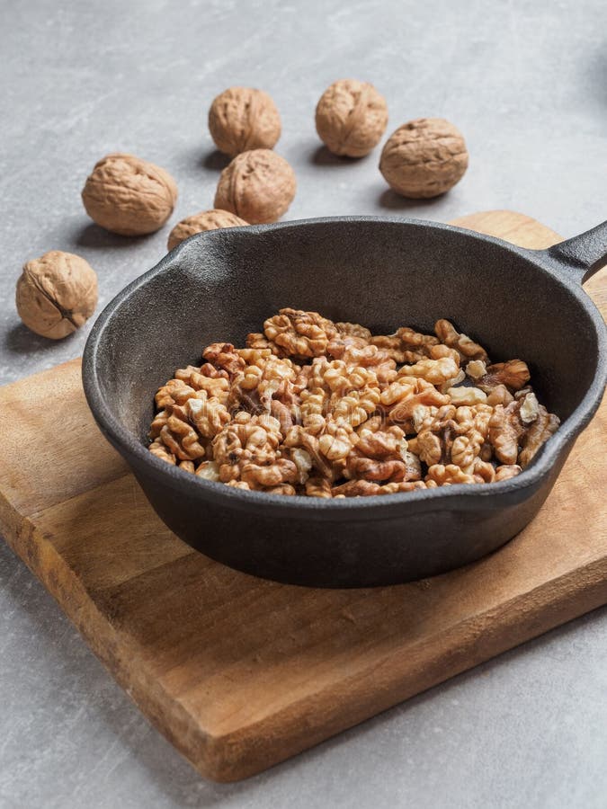 Roasted Tasty Walnuts in Black Pan Against Concrete Background. Close ...