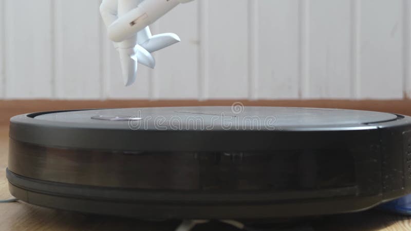 The Robot Arm Turns on the Robot Vacuum Cleaner. the Concept of the ...