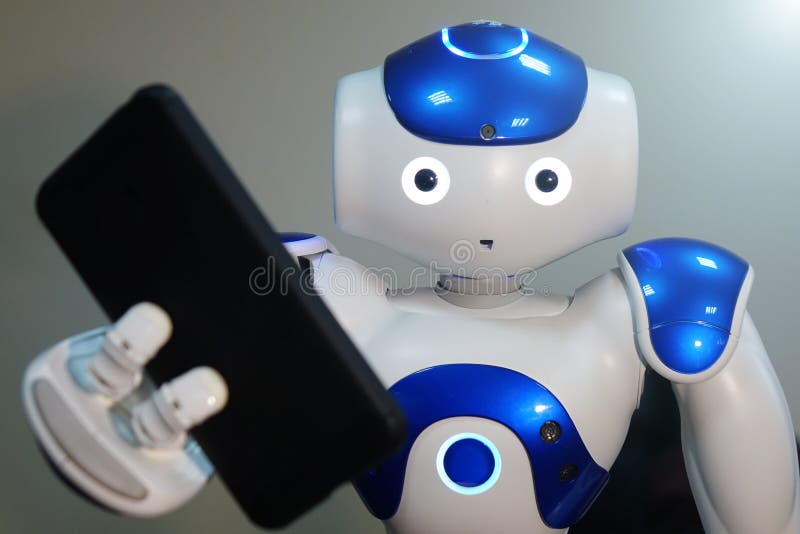 The Robot Holds the Phone in His Hand . a Small Robot with a Human Face ...