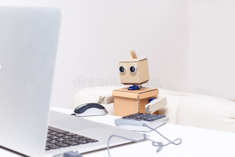 Robot is Sitting at the Table and Working at a Laptop Stock Image ...