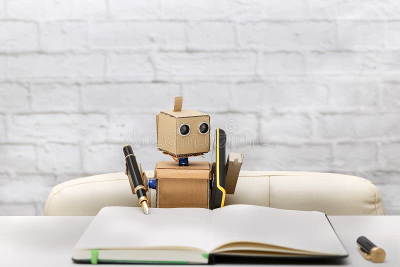 Robot Writes in Diary Pen in Black Sitting at Table Stock Photo - Image ...