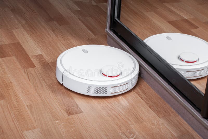 Robotic Vacuum Cleaner on Laminate Floor is Reflected in Mirror of ...