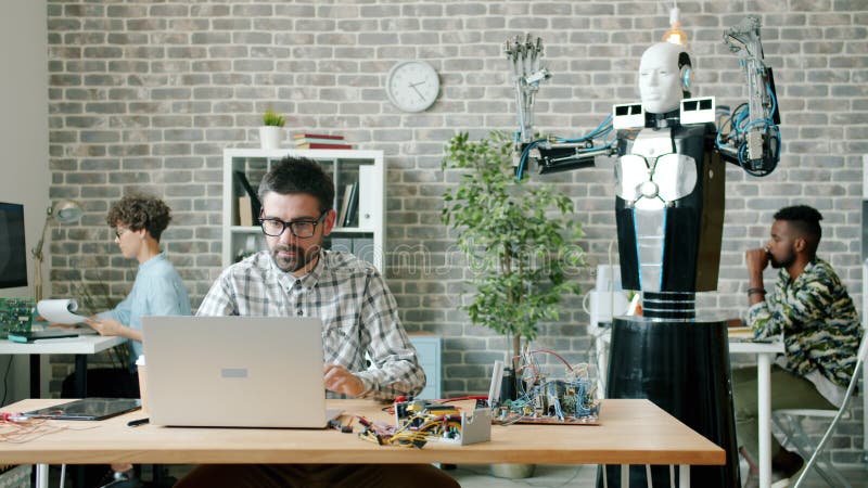 Robotics Engineer Building and Testing Robot in Office Using Wires and ...