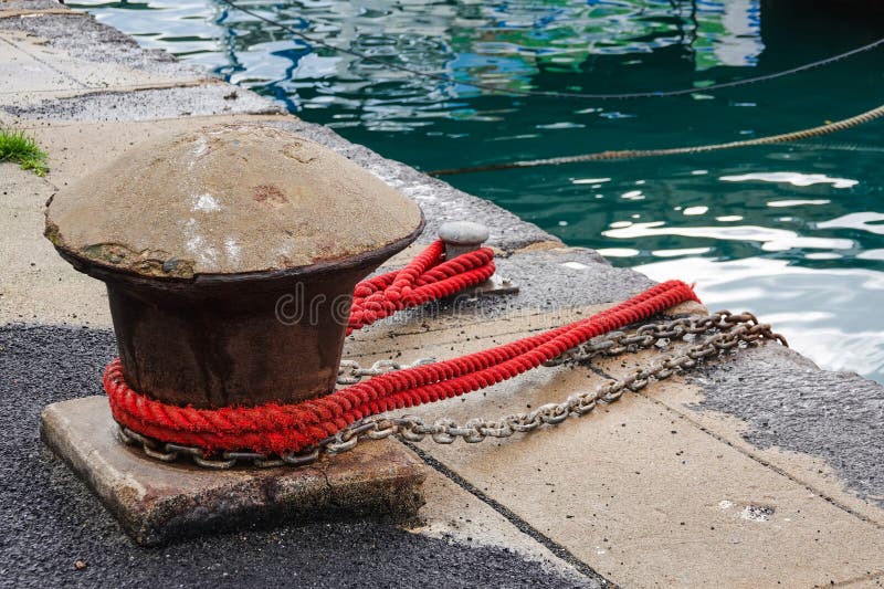 A Robust Mooring Postwith Red Ropes and Chains Wrap Around the Post ...