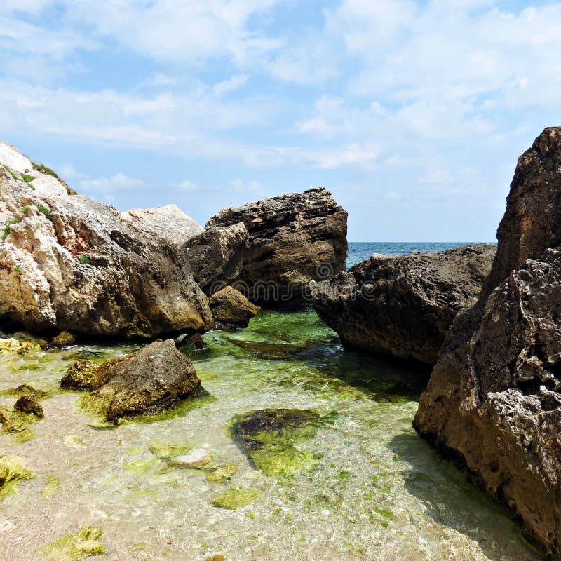 Rocas, Mar Claro Y Cielo Azul Con Nubes Blancas Imagen de archivo ...