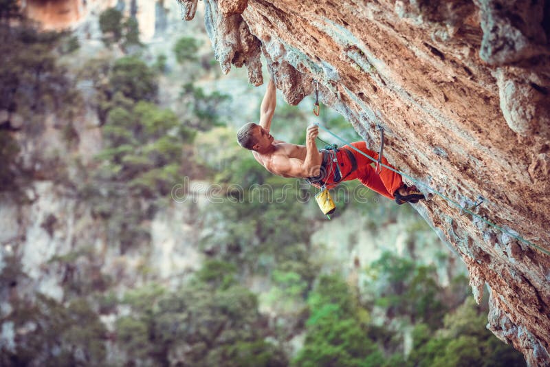 Rock Climber Clipping Rope while Climbing Challenging Route on Cliff ...