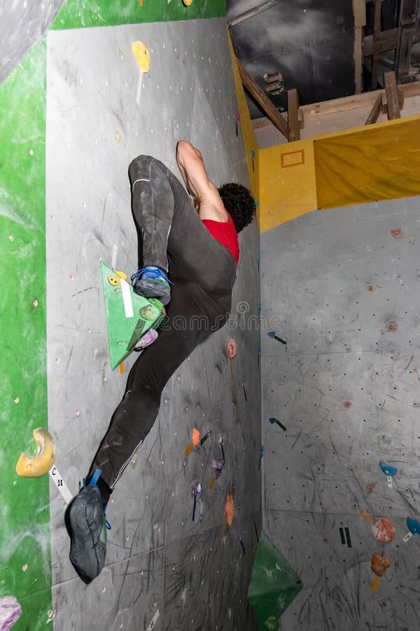 Rock Climber Man Hanging on a Bouldering Climbing Wall, Inside on ...