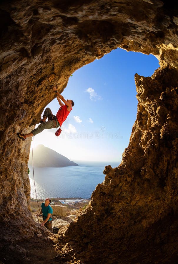 Male Rock Climber Climbing Along a Roof in a Cave Stock Photo - Image ...