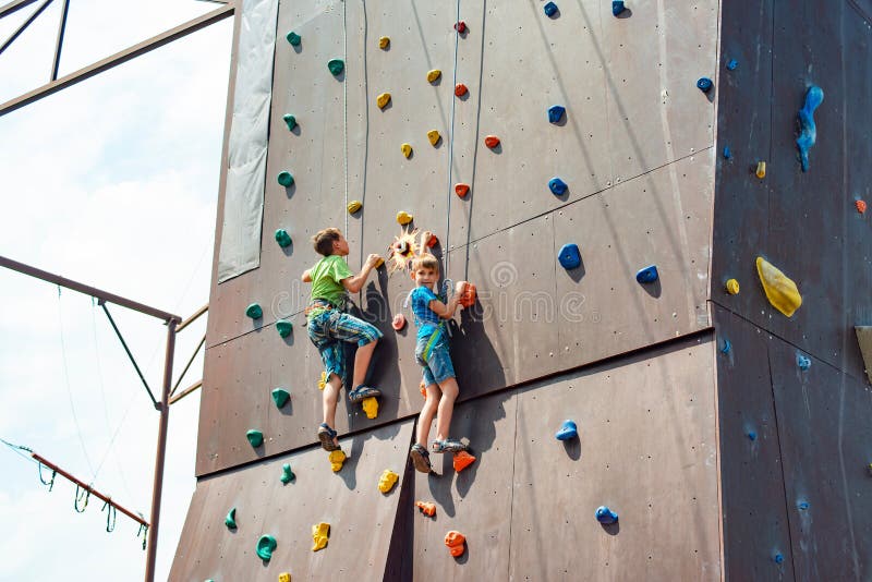 Rock Climbing on an Artificial Rise. the Boy Climbs on the Wall in an ...