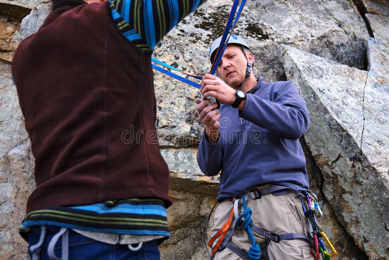 Rock Climbing Instructor is Teaching How To Perform the Belay Station ...