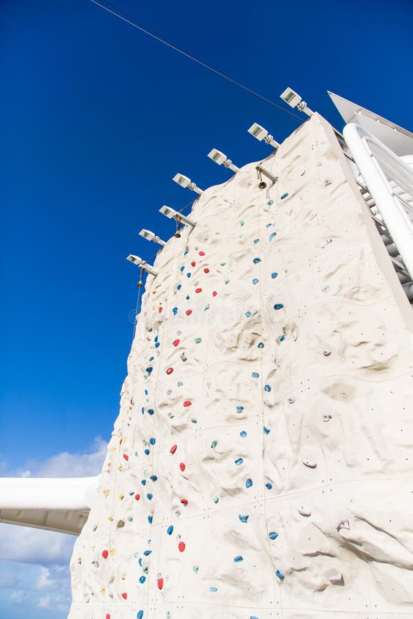 Rock Climbing Wall Under Blue Sky with Bell at Top Stock Image - Image ...