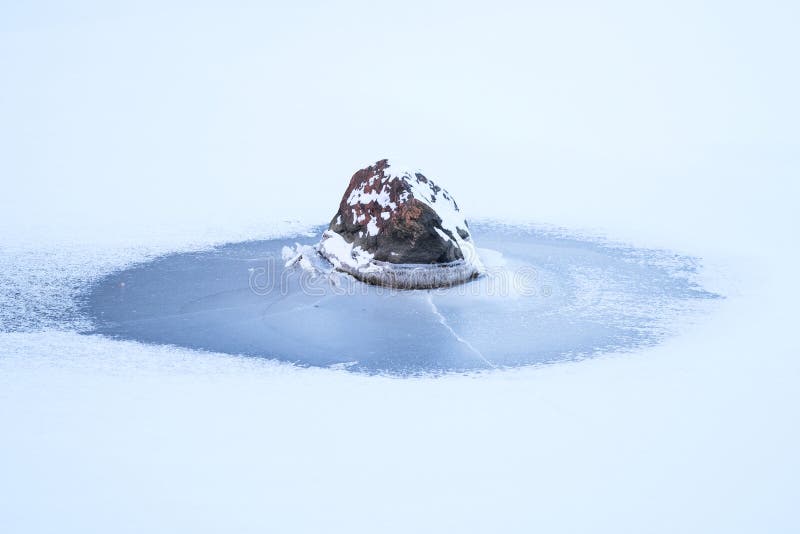 Rock in a frozen lake stock image. Image of season, lake - 362090579