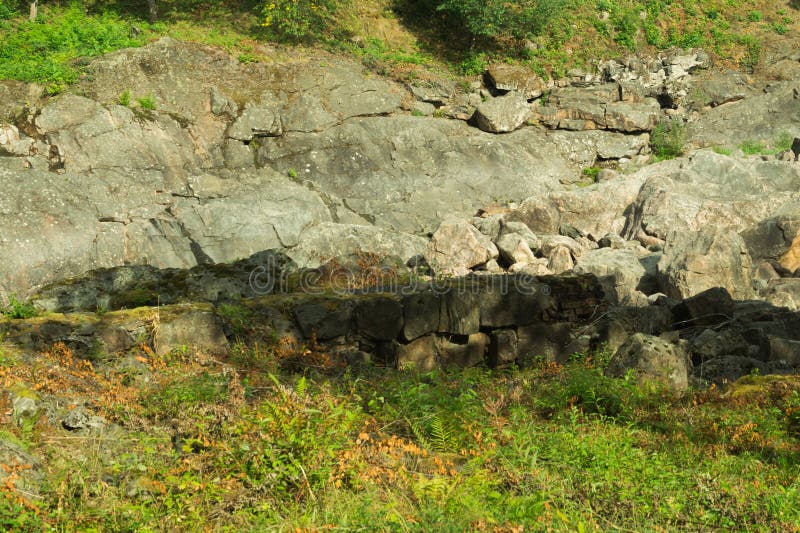 Rock of Layered Stone Overgrown with Grass and Moss. Texture of Stone ...