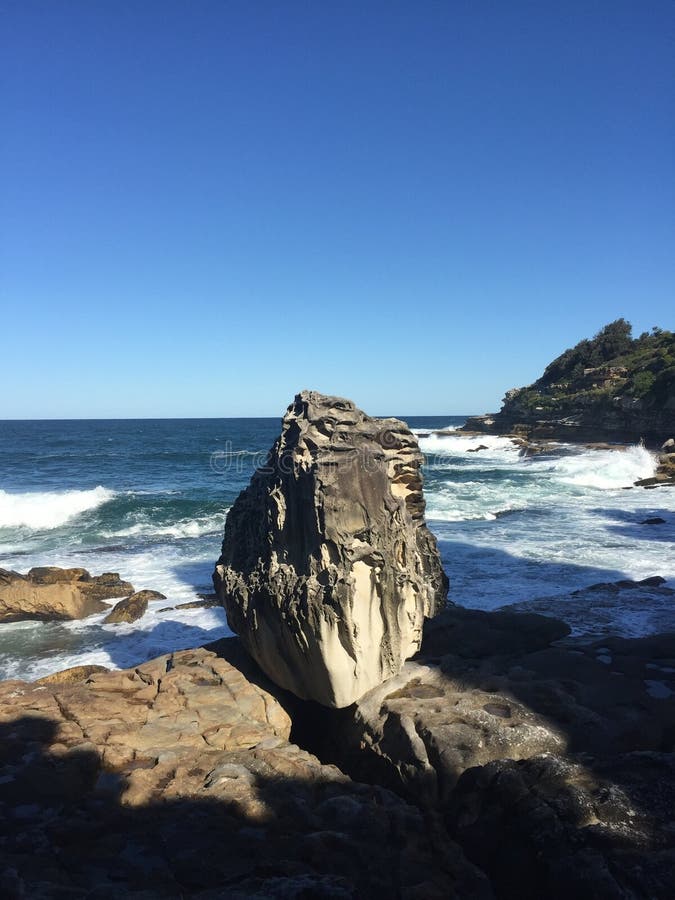 Rock in the Middle on Beach with Waves and Blue Sky Stock Image - Image ...