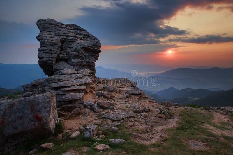 Rock Mountain Cliff Over Sunset Sky Background in Stock Photo - Image ...