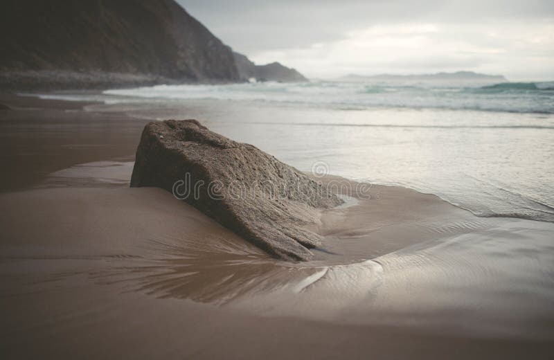 Rock in the sand stock image. Image of water, spain, scenery - 58450997
