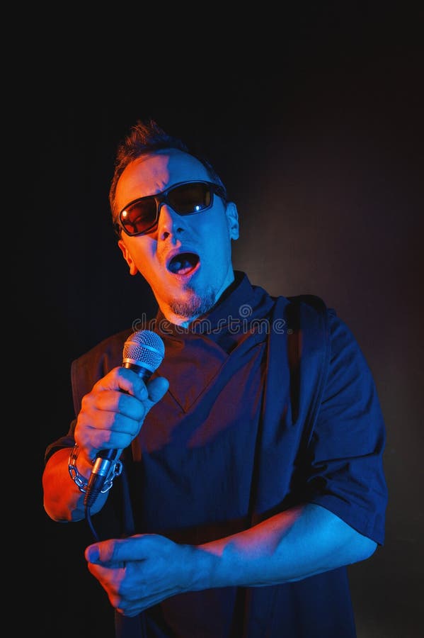 Rock Singer Sings with Microphone and Sunglasses Against Red and Blue ...