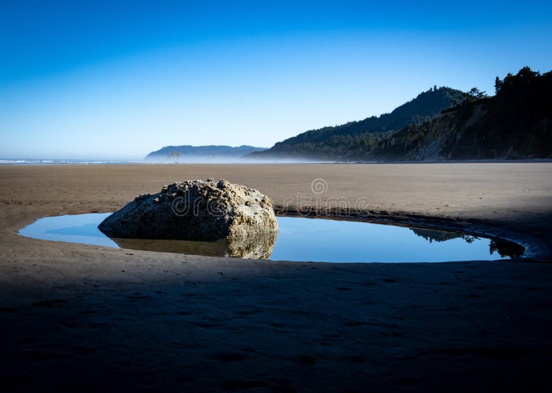 Rock in Tide Pool with View Down the Beach at Hug Point in Oregon Stock ...