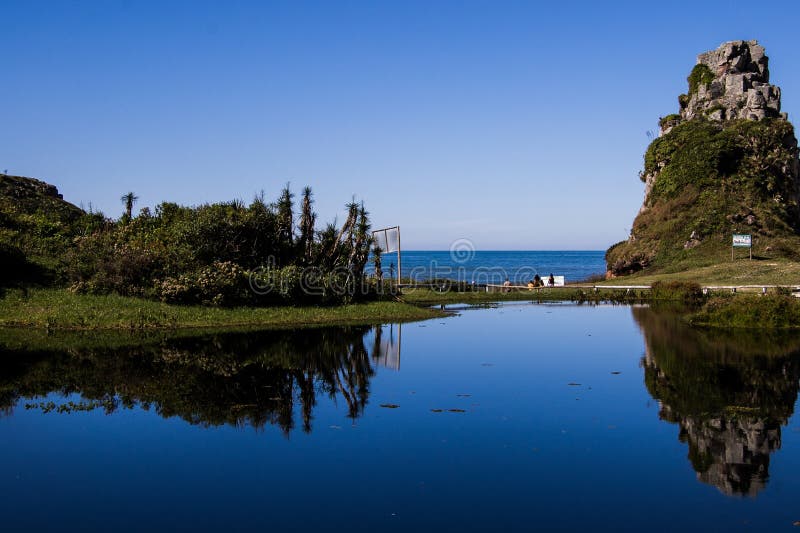 Rock and Vegetation Reflection in Seaside Lagoon Stock Photo - Image of ...