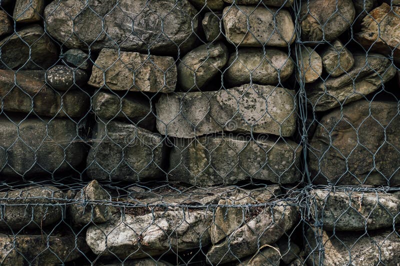 Rock Wall Construction Method Showcasing Natural Stones Enclosed in ...