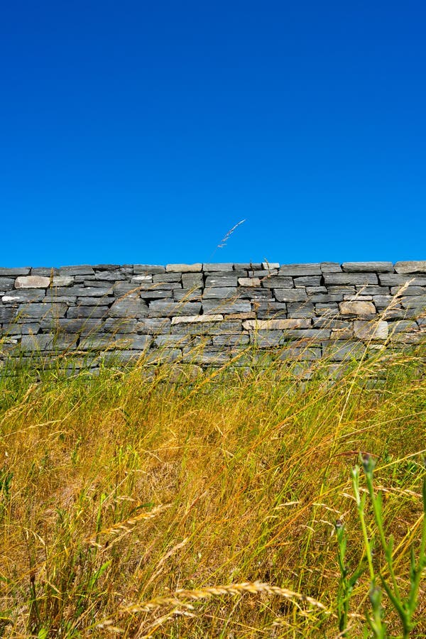 Rock Wall on Top of a Grass Incline.. Stock Photo - Image of stone ...