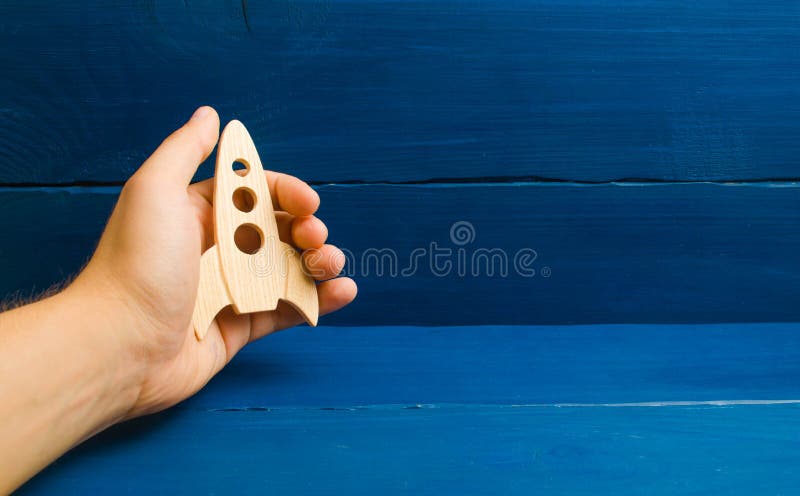 Rocket in Hand Concept. the Hand Holds a Wooden Rocket. the Rocket is ...