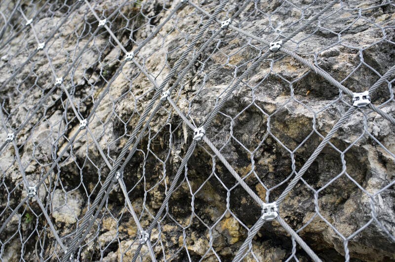 Rockfall Protection Netting on Cracked Rocks Stock Photo - Image of ...