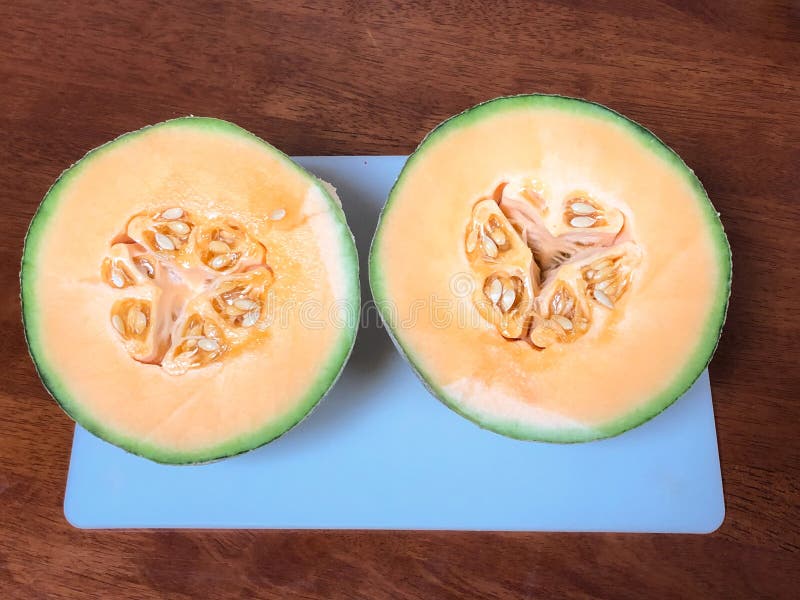 Rockmelon Cut into Half on a White Cutting Board Stock Image - Image of ...