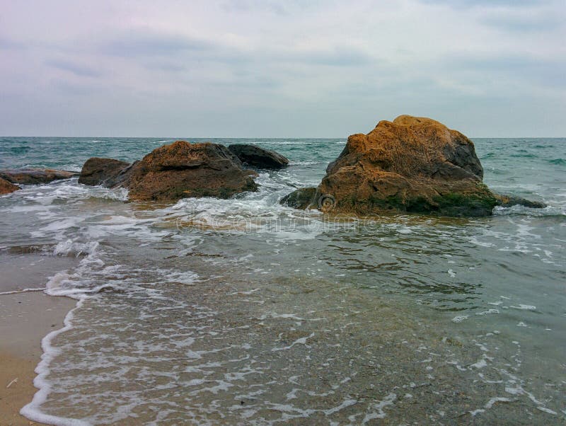 Rocks on beach stock photo. Image of ocean, clouds, sand - 79080970