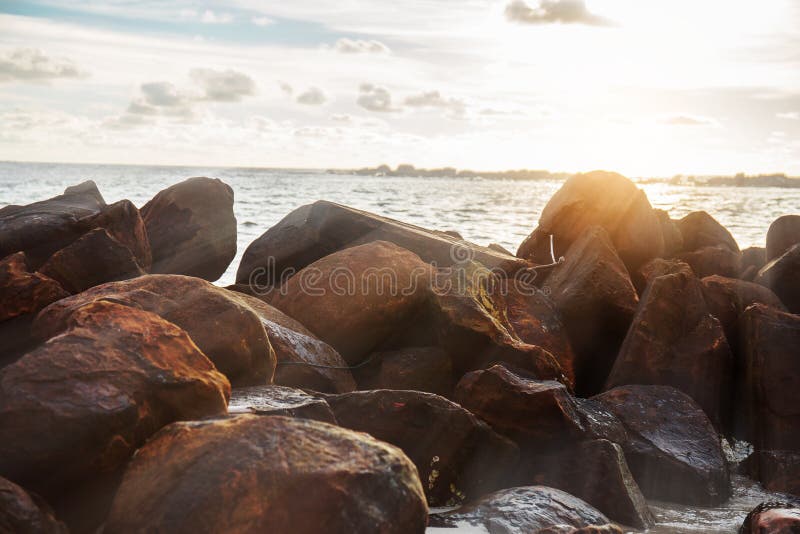 Rocks on beach at sunset. stock image. Image of outdoor - 128261515