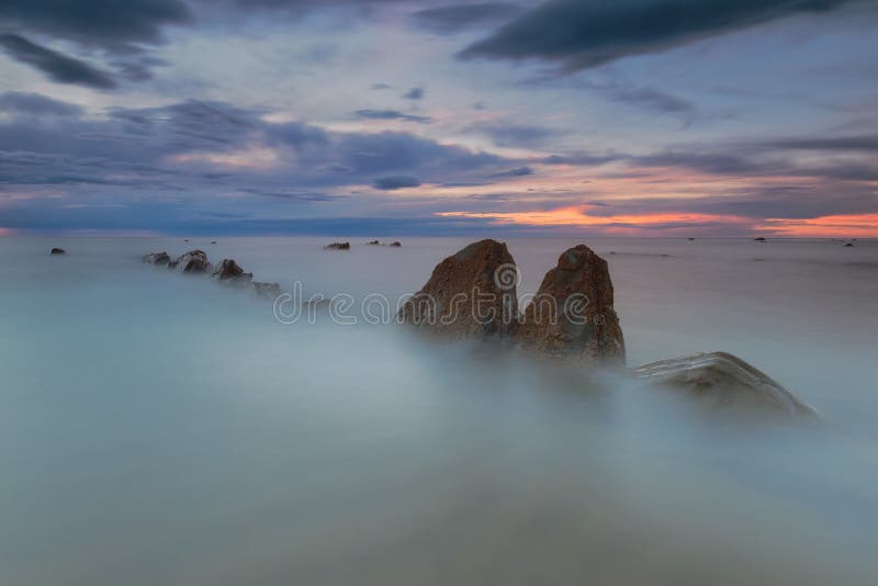 Rocks on calm waters stock image. Image of beach, cloud - 26861779