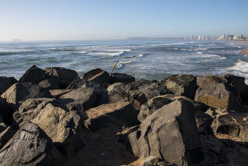 Rocks on Durban Beach with Cityscape in Distance Stock Photo - Image of ...