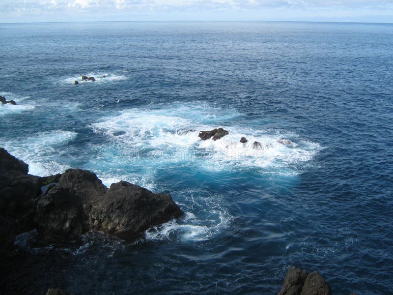 Rocks on the Ocean. Bright Blue Bubbling Water Around the Rocks Stock ...