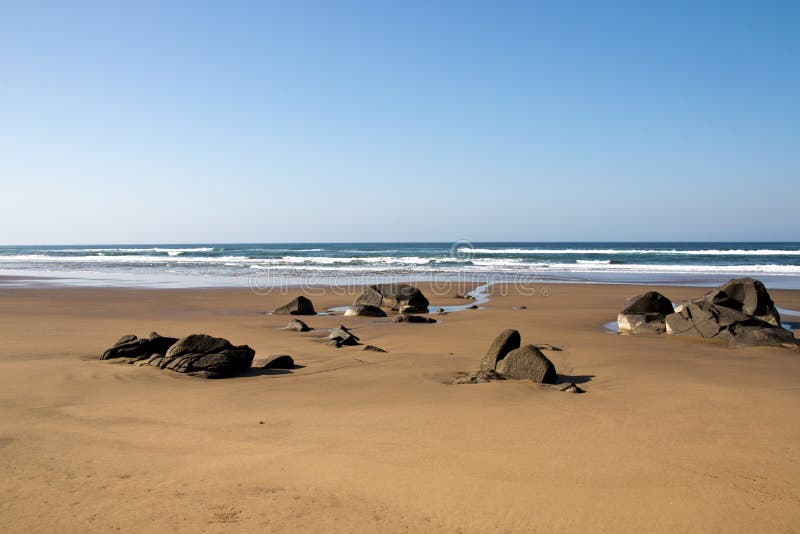 Rocks Protruding from Sandy Beach at Low Tide Stock Photo - Image of ...