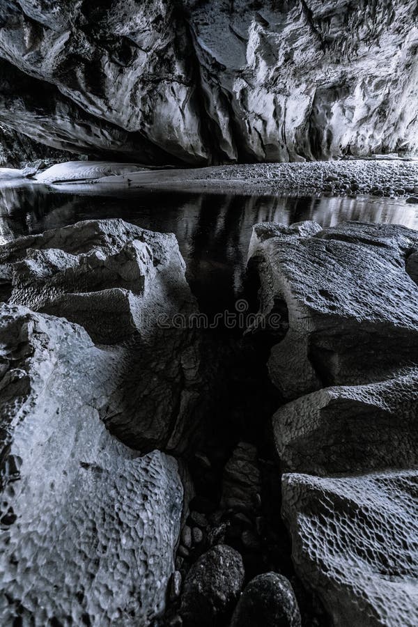 Rocks Sticking Out of the Water Under the Cliff Stock Photo - Image of ...