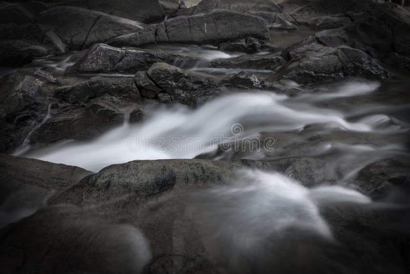 Rocks in Stream with Smooth Flowing Water. Stock Photo - Image of ...