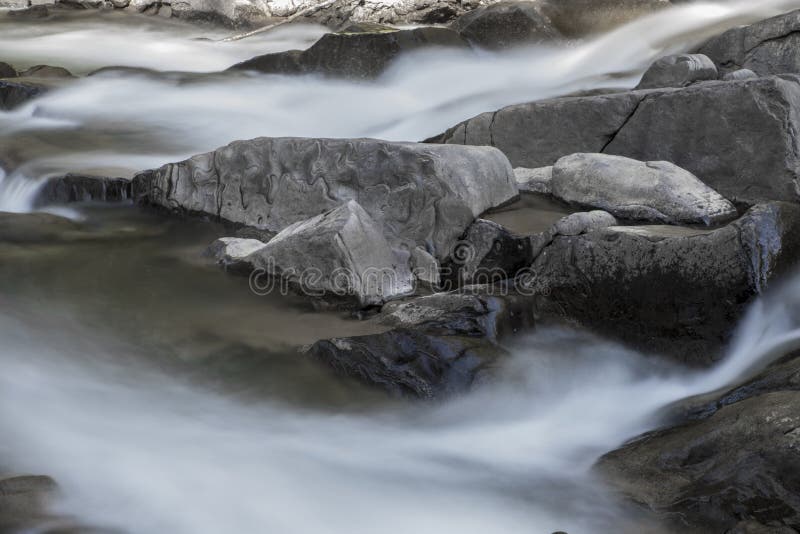 Rocks in Stream with Smooth Flowing Water. Stock Photo - Image of ...