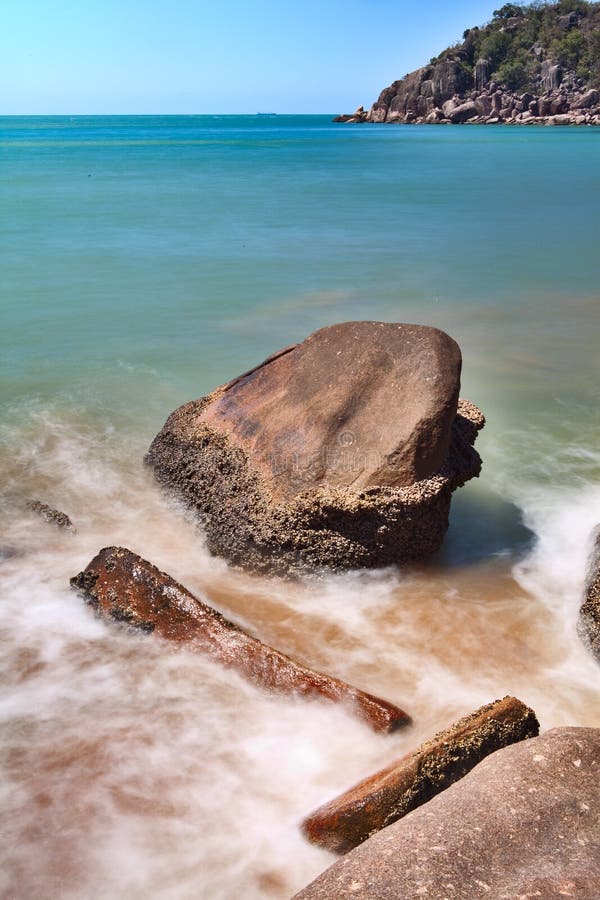 Rocks in surf on beach stock image. Image of surface - 21630767
