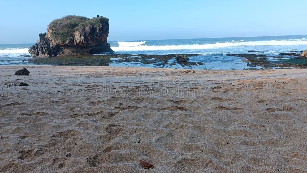 A Rocky Beach with a Large Rock in the Foreground Stock Image - Image ...