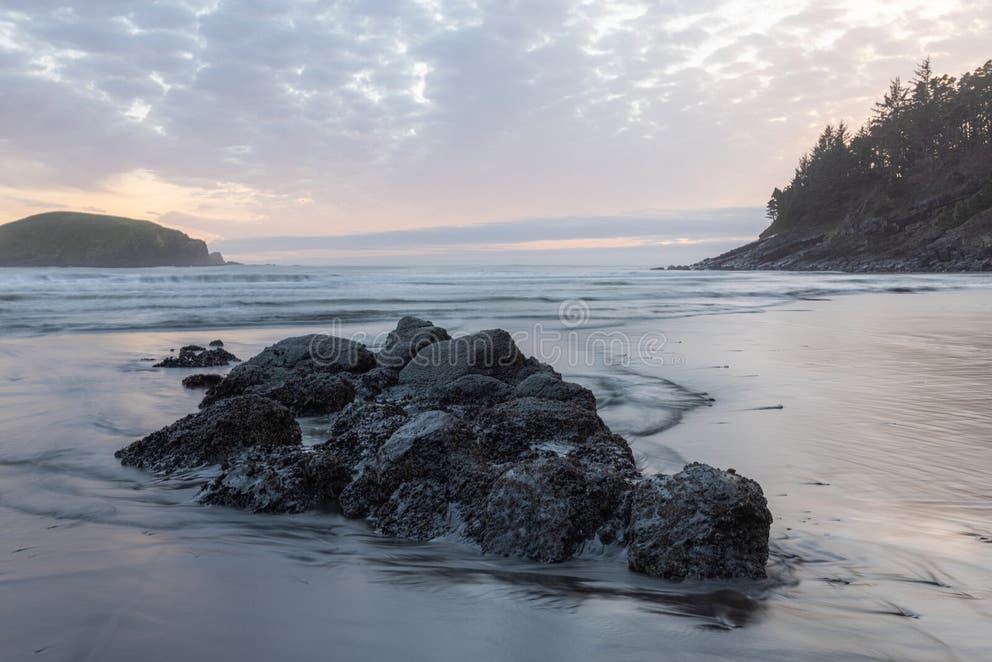 A Rocky Beach with a Large Rock in the Foreground Stock Photo - Image ...