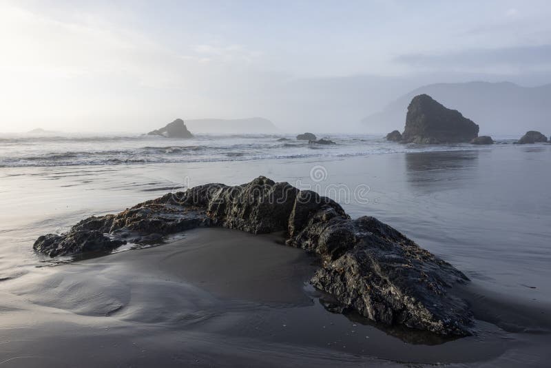 A Rocky Beach with a Large Rock in the Foreground Stock Photo - Image ...
