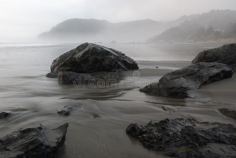 A Rocky Beach with a Large Rock in the Foreground Stock Image - Image ...