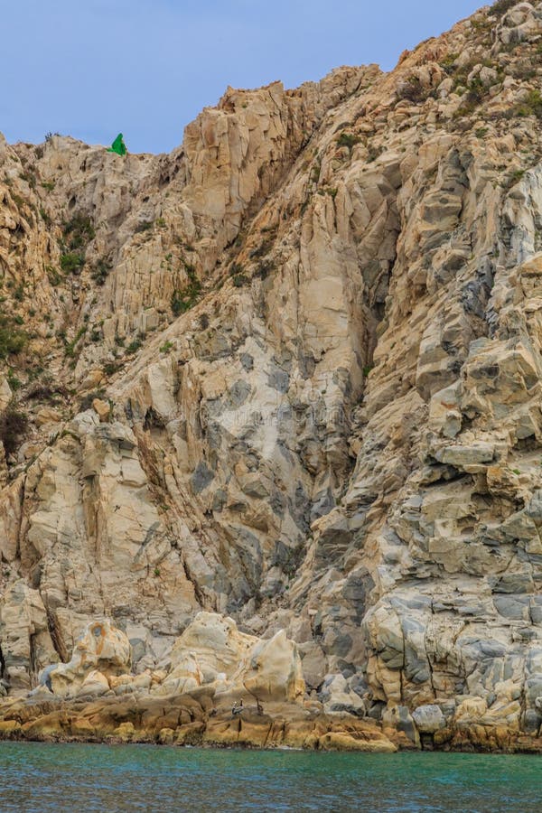 A Rocky Cliff with a Green Statue on Top Stock Photo - Image of scenic ...
