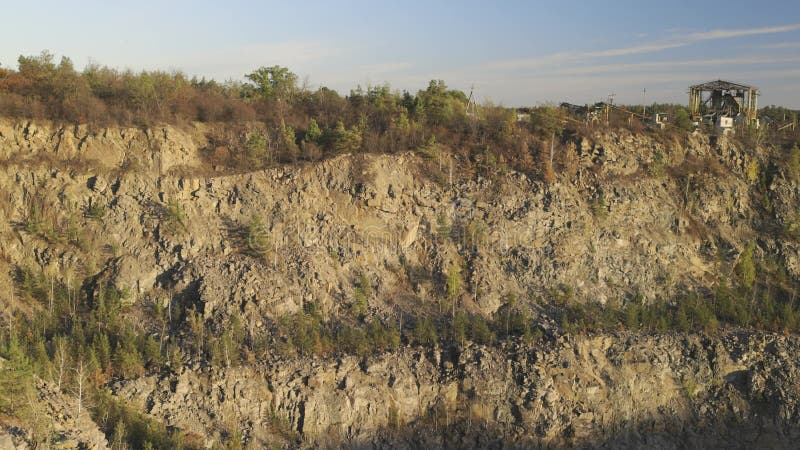 A Rocky Cliffside with Sparse Vegetation, Including Dry Bushes and a ...