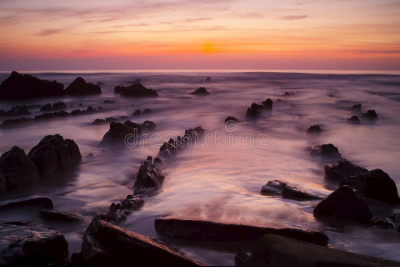 Rocky coastline sunset stock photo. Image of cloudscape - 1210290