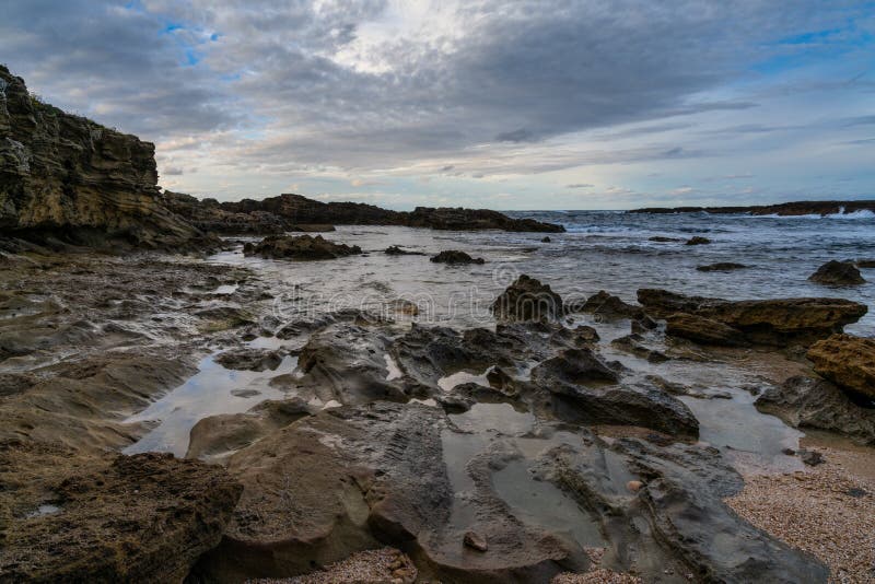 Rocky Cove and Sandy Beach Under an Expressive Sky on the Rugged West ...